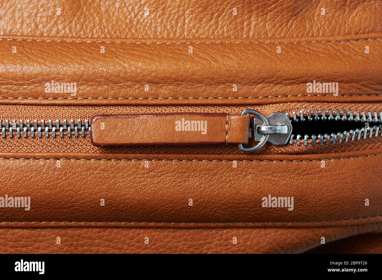Open zip lock on brown leather background close up view Stock Photo - Alamy