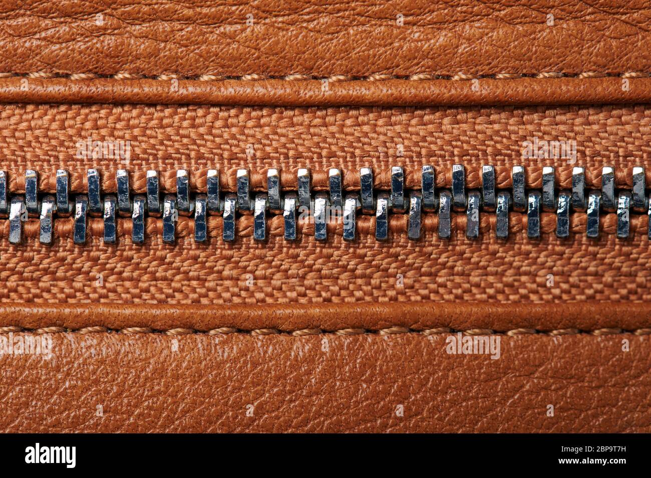 Metal zipper close up view on brown leather background Stock Photo - Alamy
