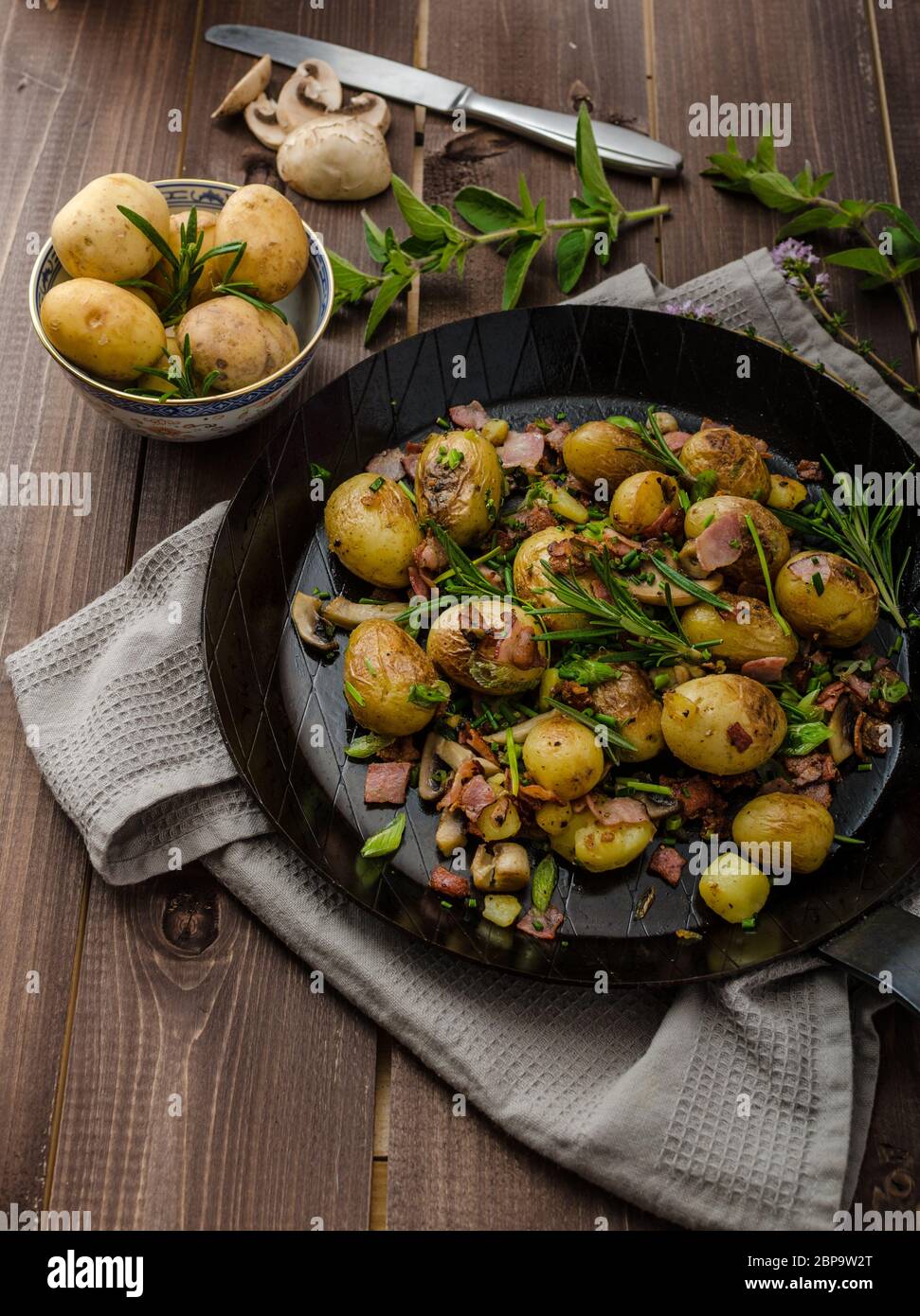Sauteed new potatoes with bacon and herbs Stock Photo - Alamy