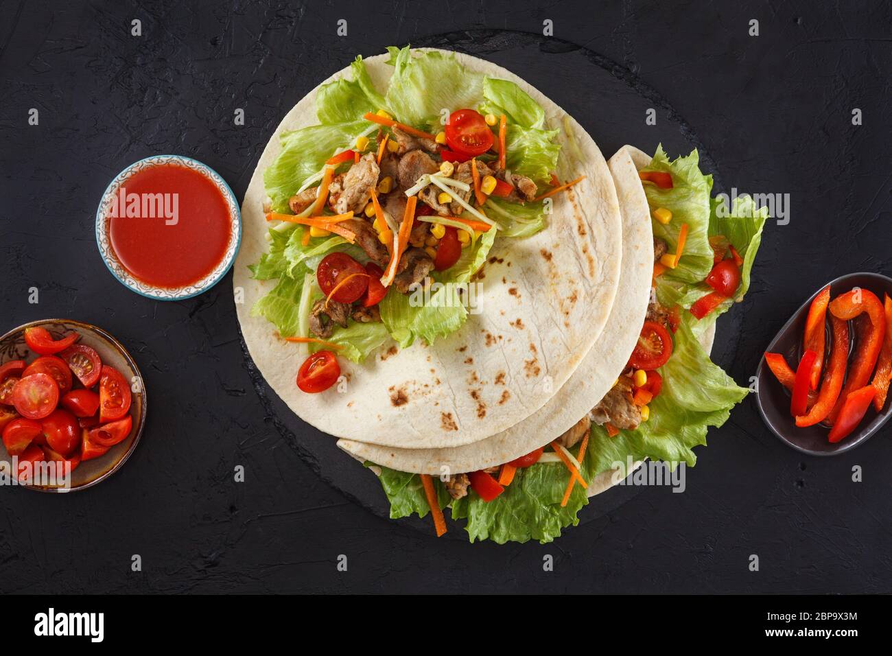 Burritos wraps with chicken and vegetables on black slate. Chicken burrito, mexican food Stock ...