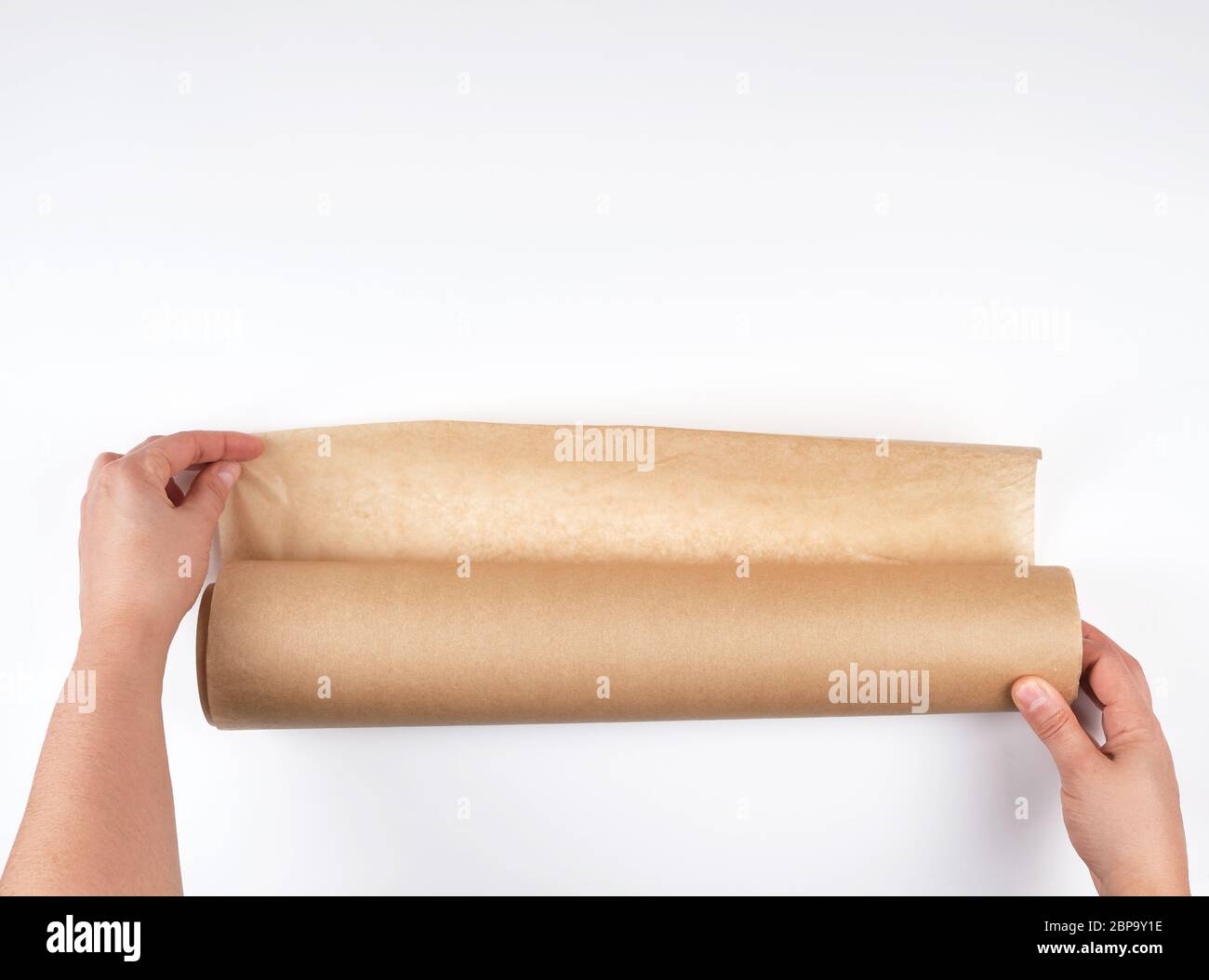 roll of brown parchment paper for baking food in female hands, white ...