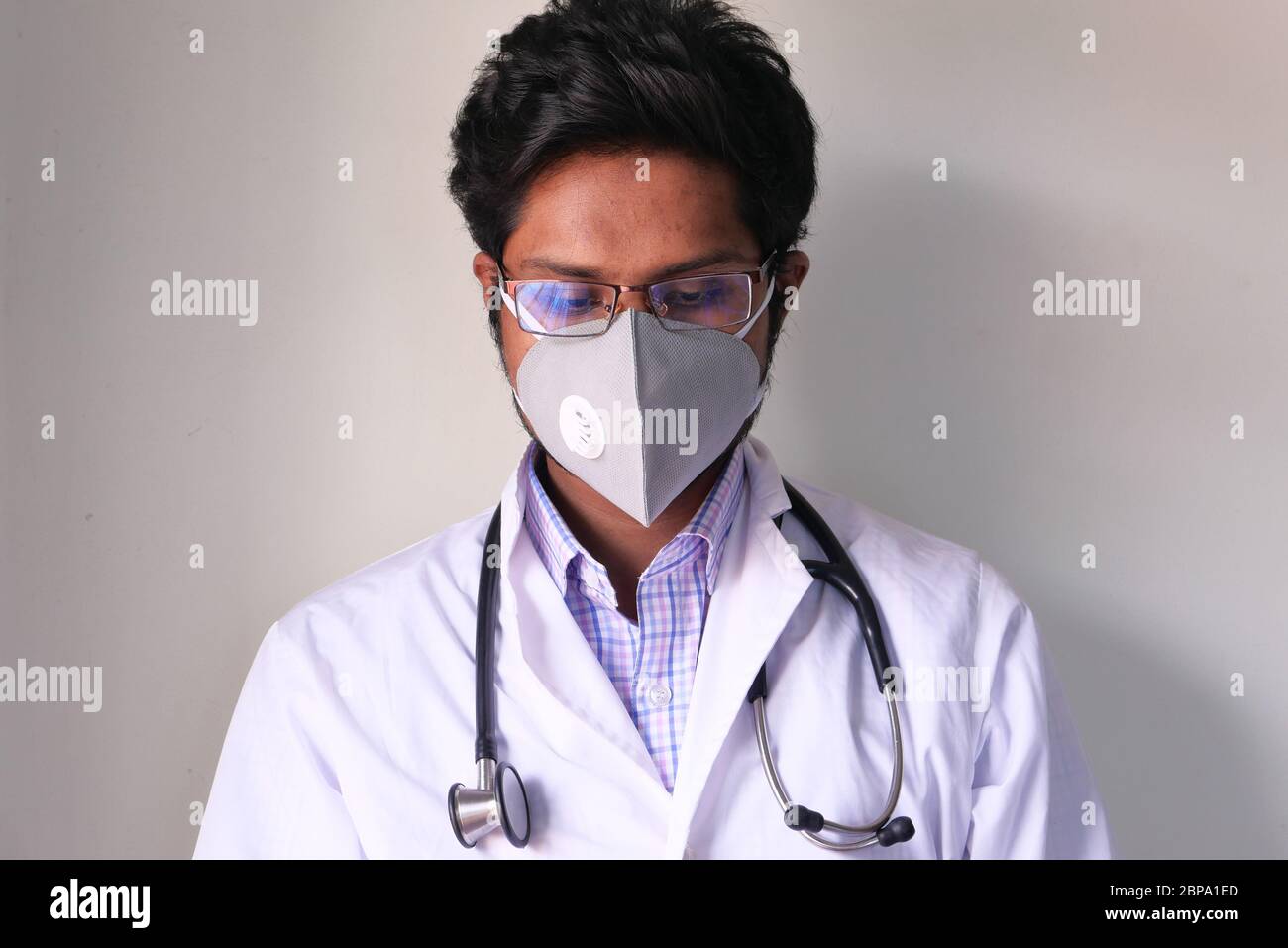 doctor with face mask looking down Stock Photo - Alamy