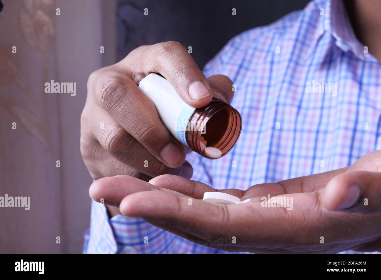 pouring pills from bottle on hand indoor Stock Photo - Alamy