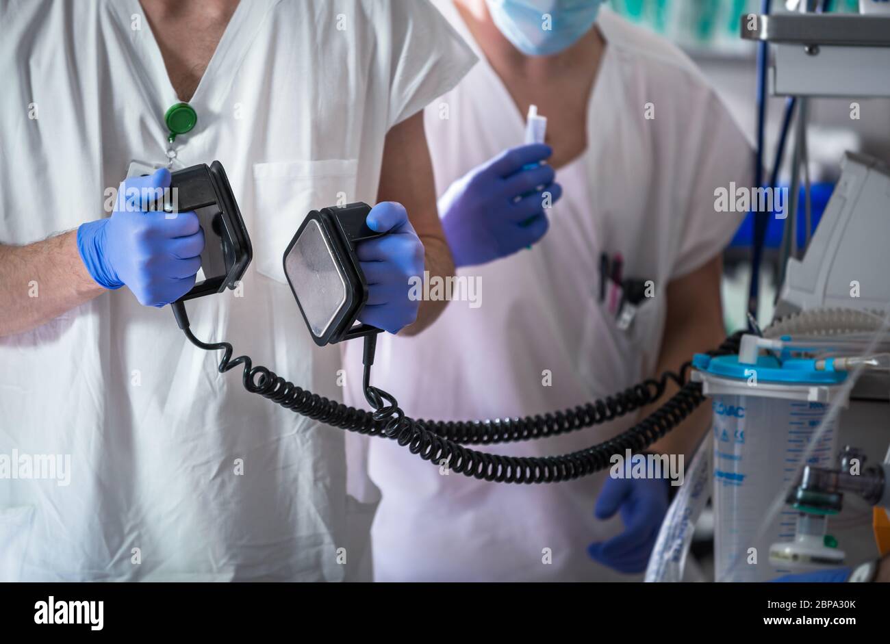 Doctor holding defibrillator electrods, performing defibrillation on a ...