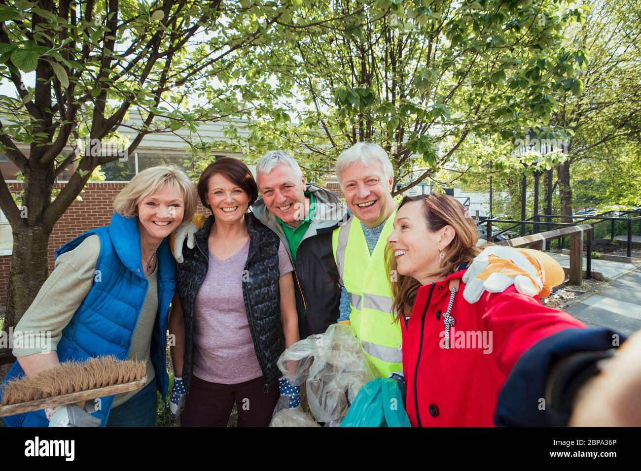 A group of five people who are participating in a city clean-up taking ...