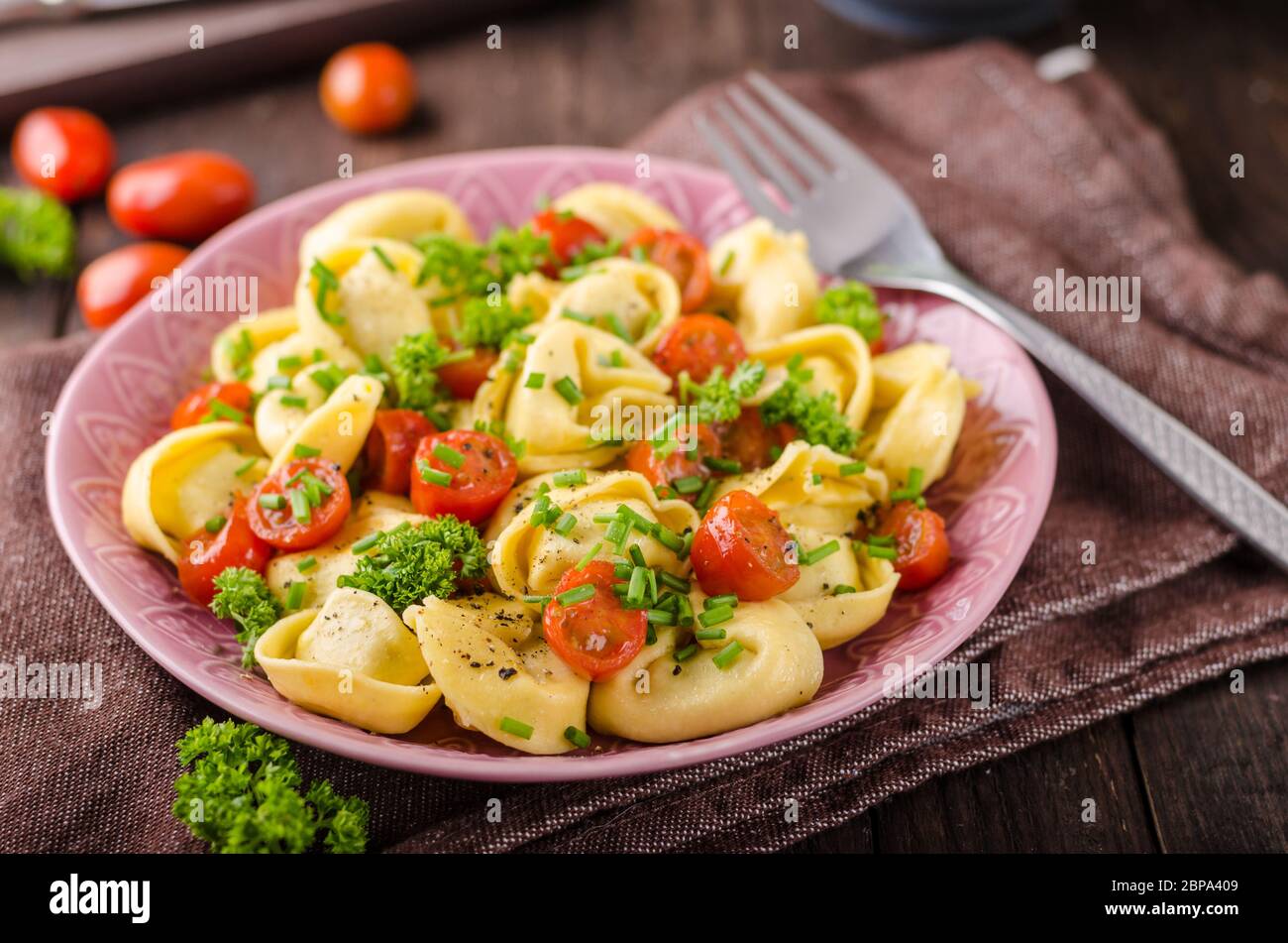 Filled tortellini with herbs, tomatoes, fresh cheese, food photography, product photo Stock ...