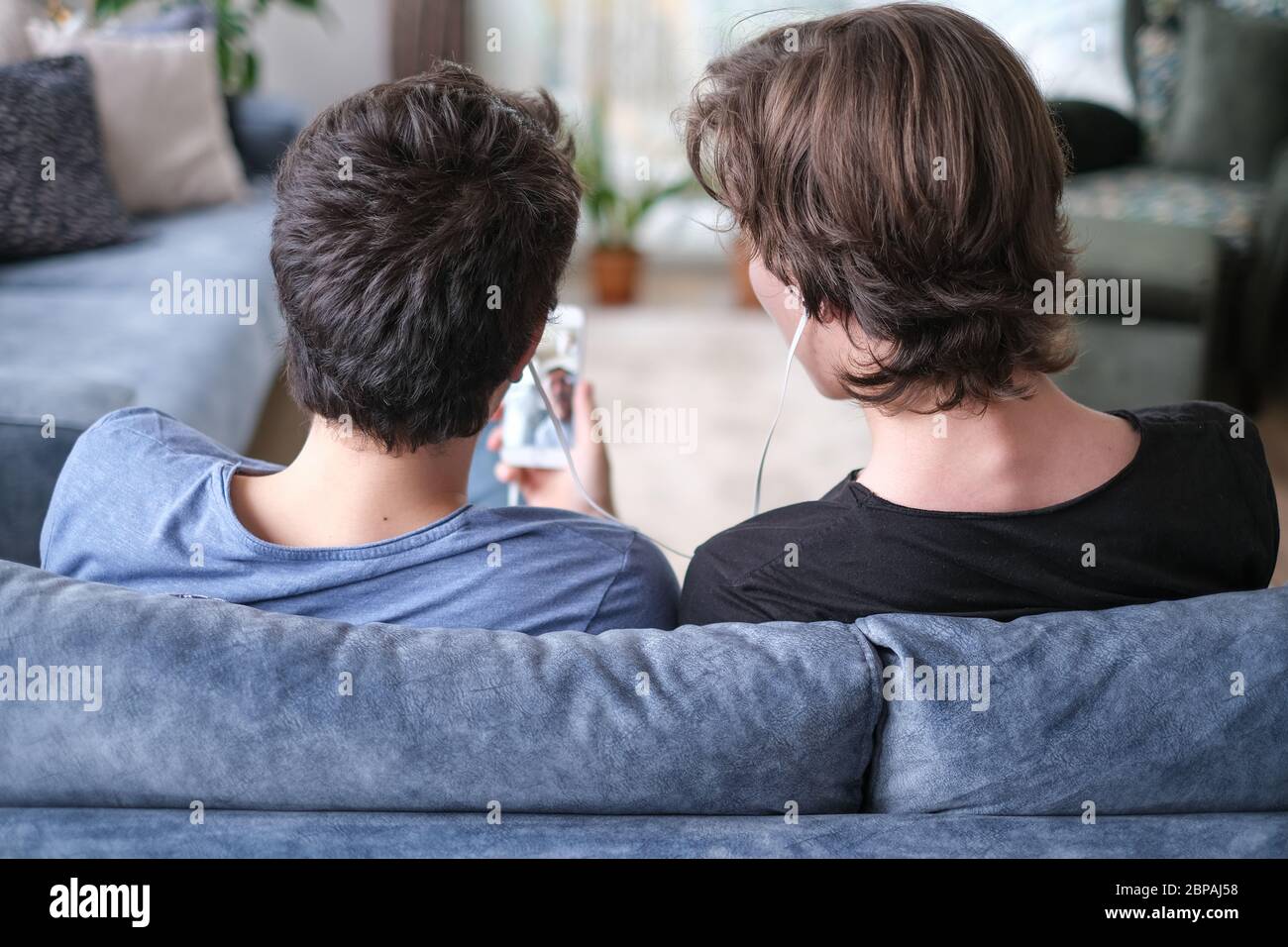 Two brothers are video chatting on smart phone with their father in ...