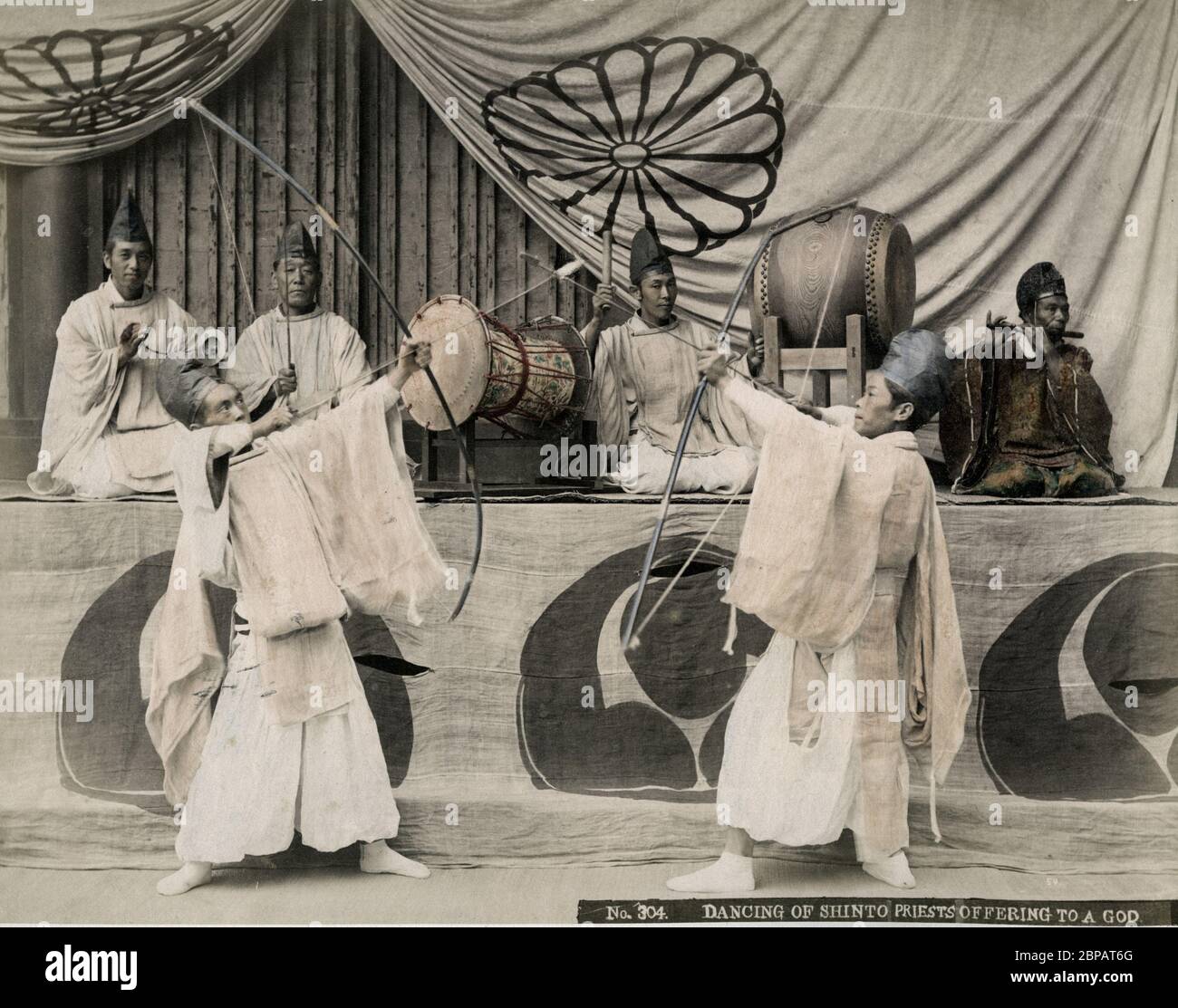 Shinto priests in ritual religious dance with bows and arrows, with ...
