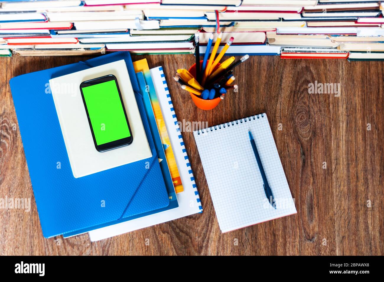 Textbook, notebook, green screen mobile phone smartphone and stack of ...