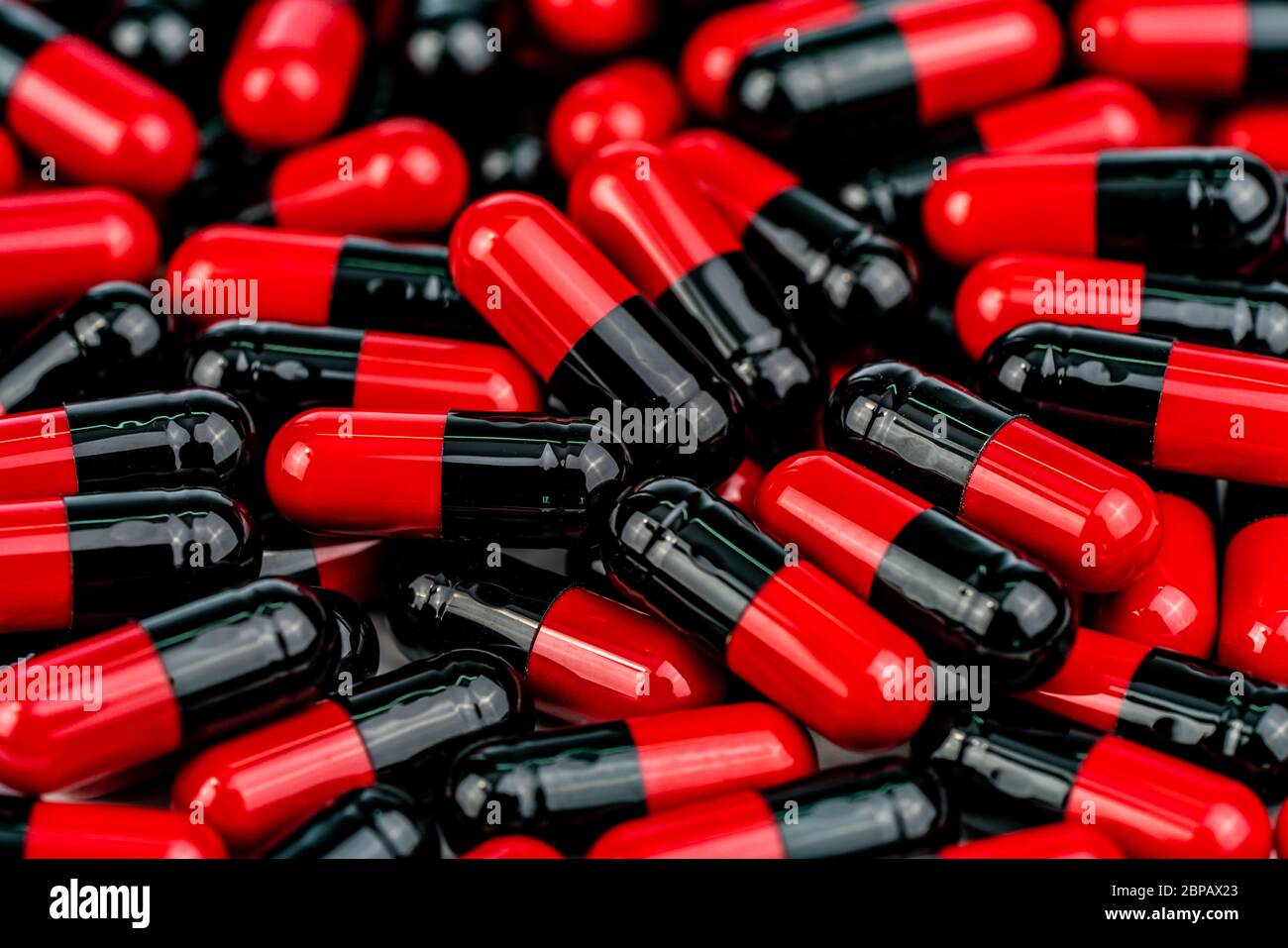 Pile of red-black capsule pills. Antibiotics resistance. Drug use with ...