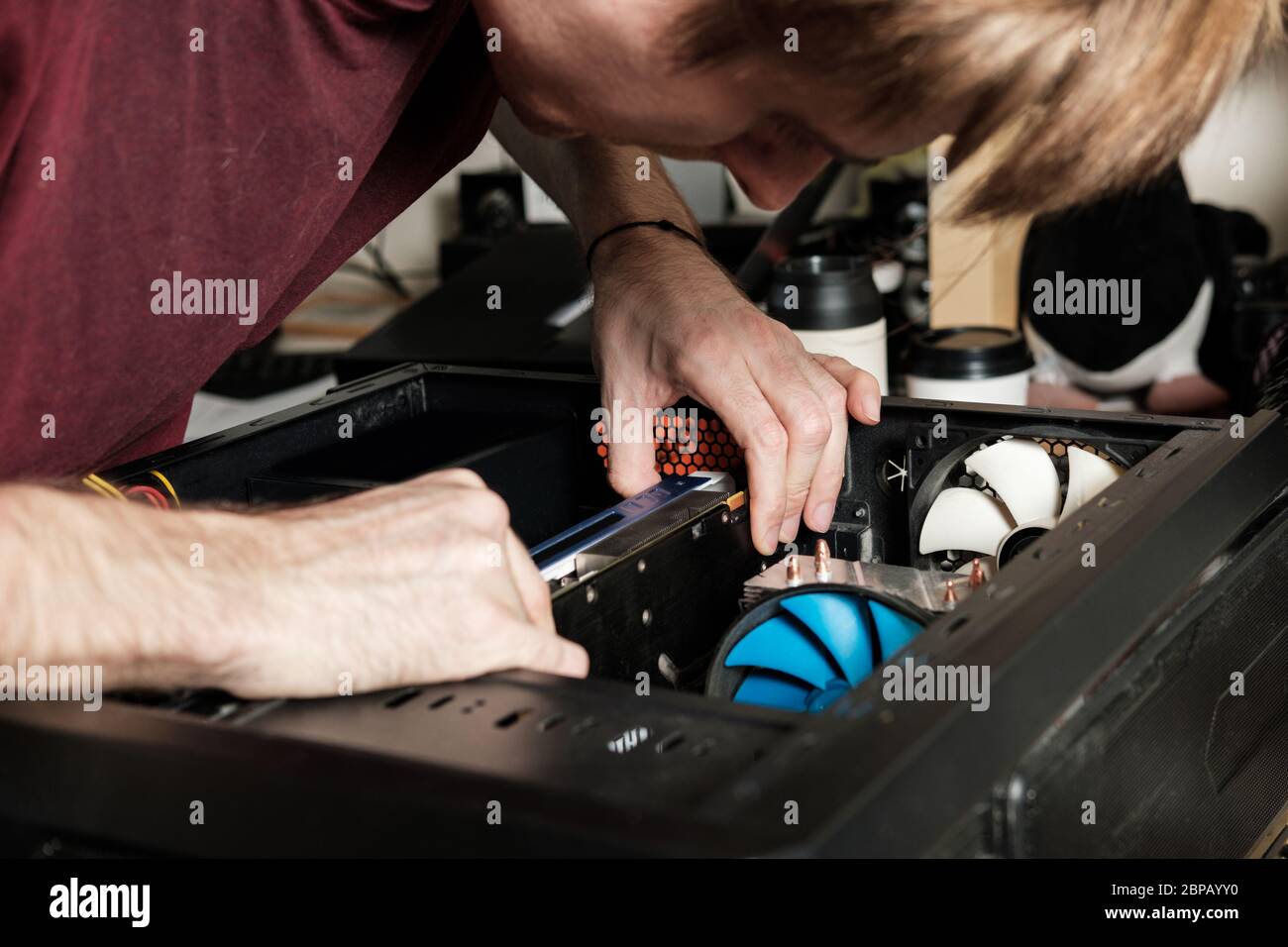Man repairs a computer system unit, changes parts, video card and hard ...