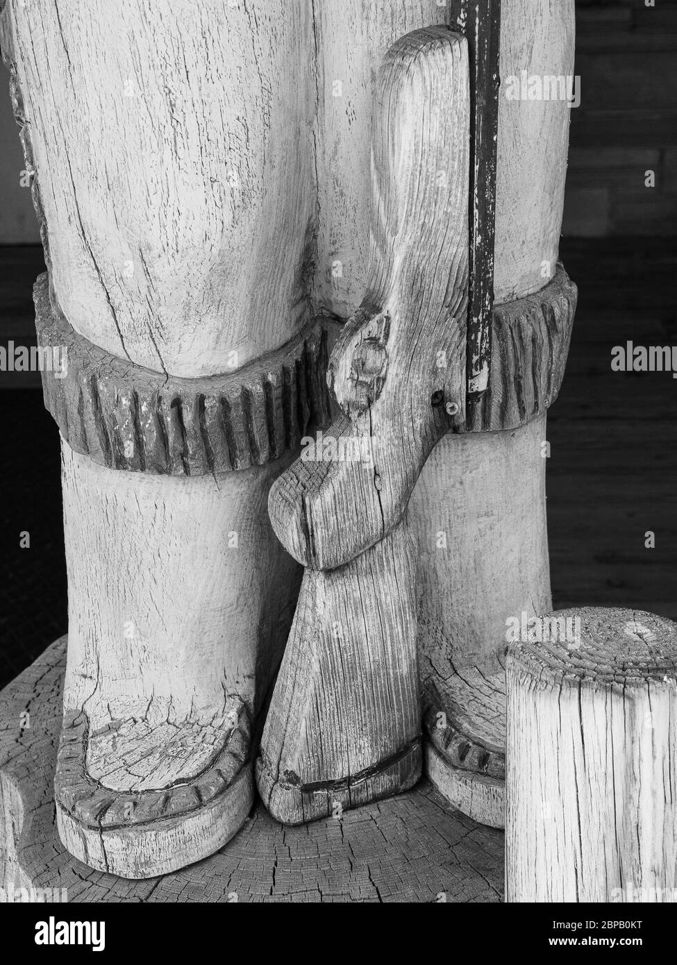 Lower legs and gun butt of wooden human carving Stock Photo - Alamy