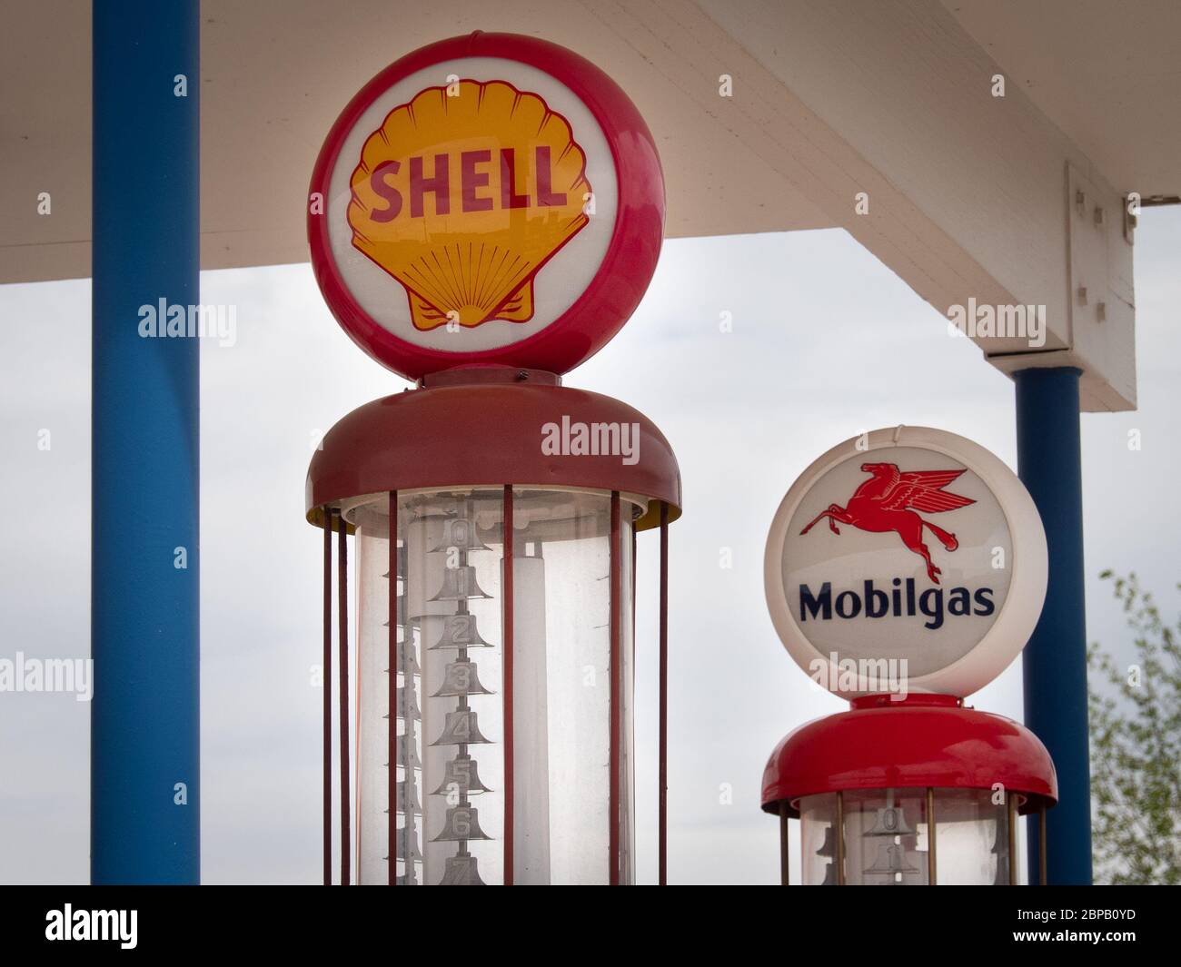 Two 1950's era gas station pump signs are isolated against an overcast ...