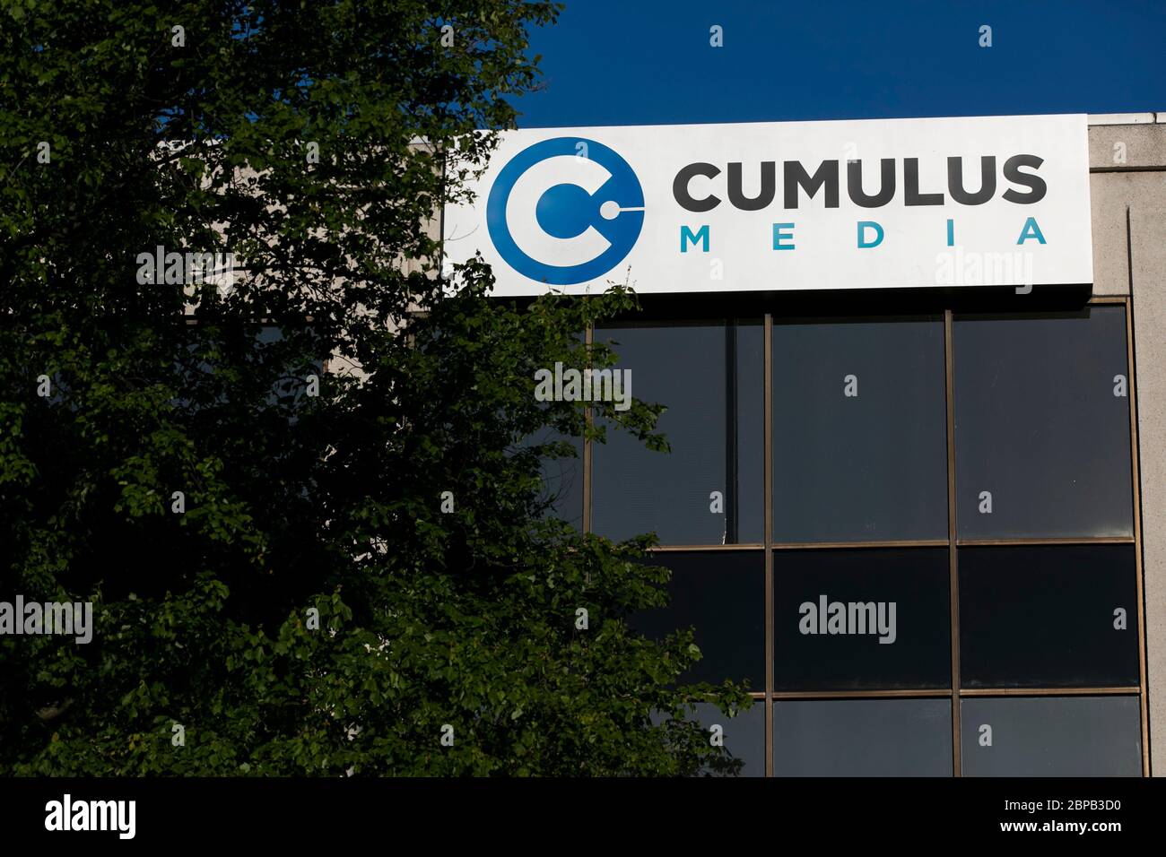 A logo sign outside of a facility occupied by Cumulus Media in ...