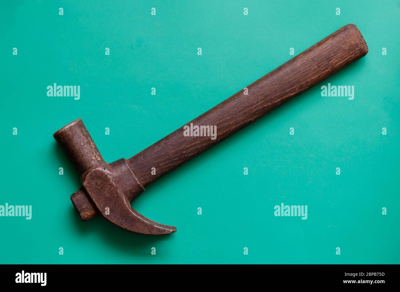 Old rusty hammer on a turquoise background. Single vintage hammer with ...