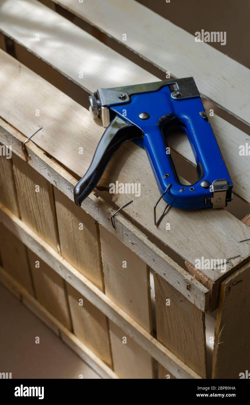 An industrial stapler lies on a new wooden box. Used stapler on the ...