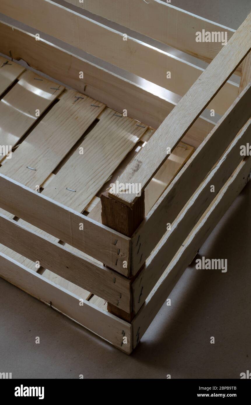 Empty new wooden box made of thin slats. Play of sun and shadow on a ...