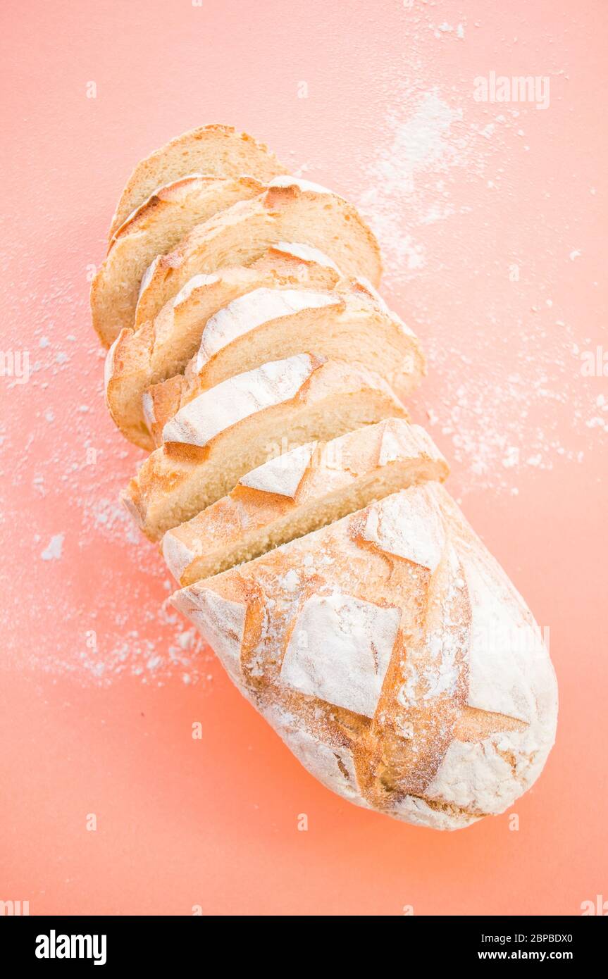 Freshly backed wholegrain bread covered with flour on orange color ...