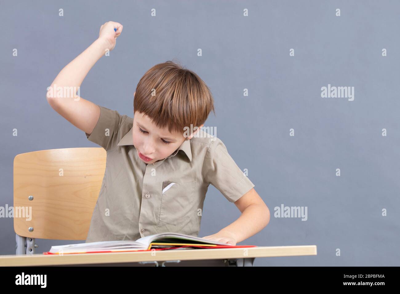 A primary school student is doing homework. The child at the desk with ...