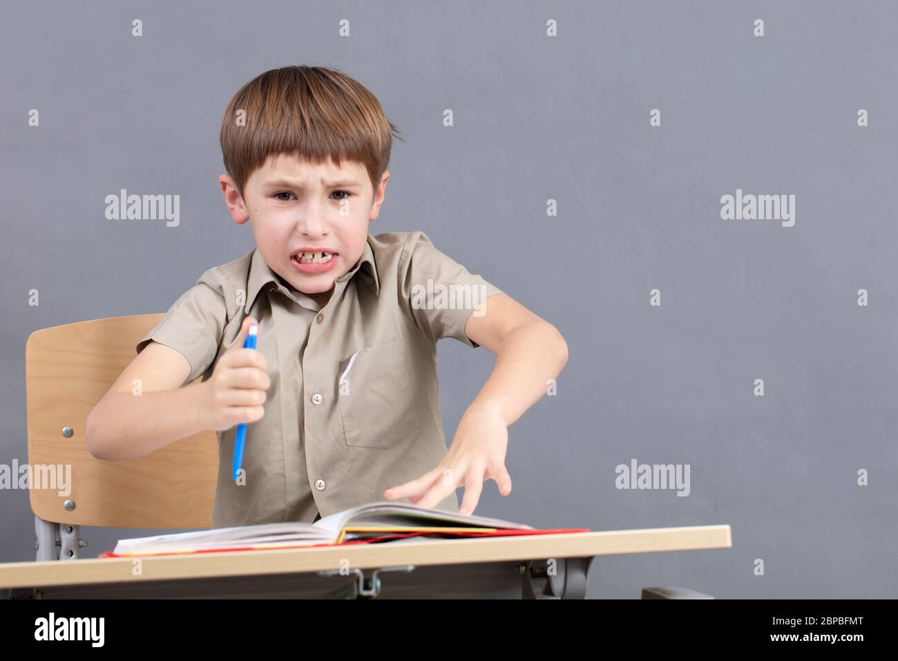 A primary school student is doing homework. The child at the desk with ...