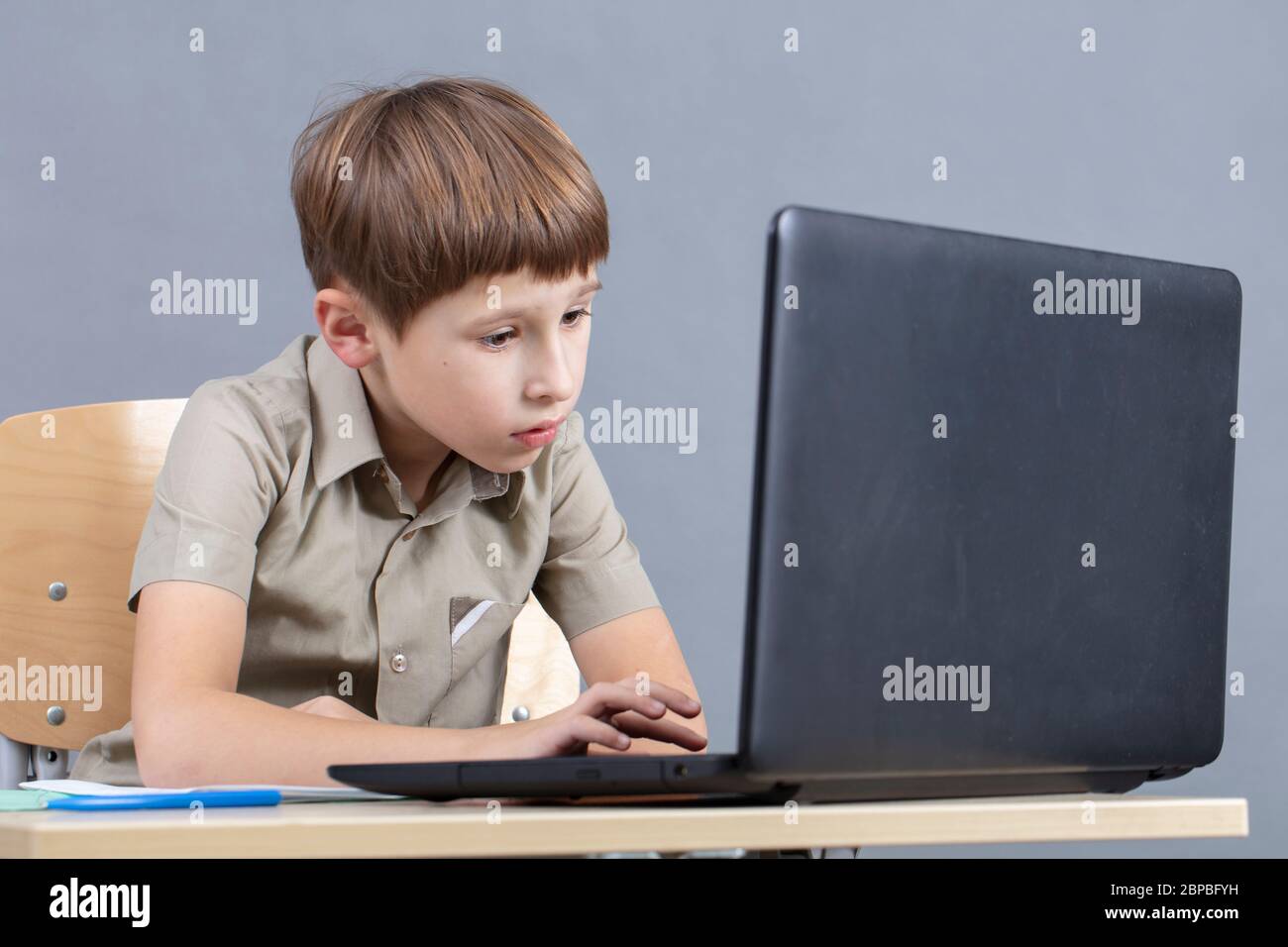 The child at the laptop. The boy looks at the monitor screen ...