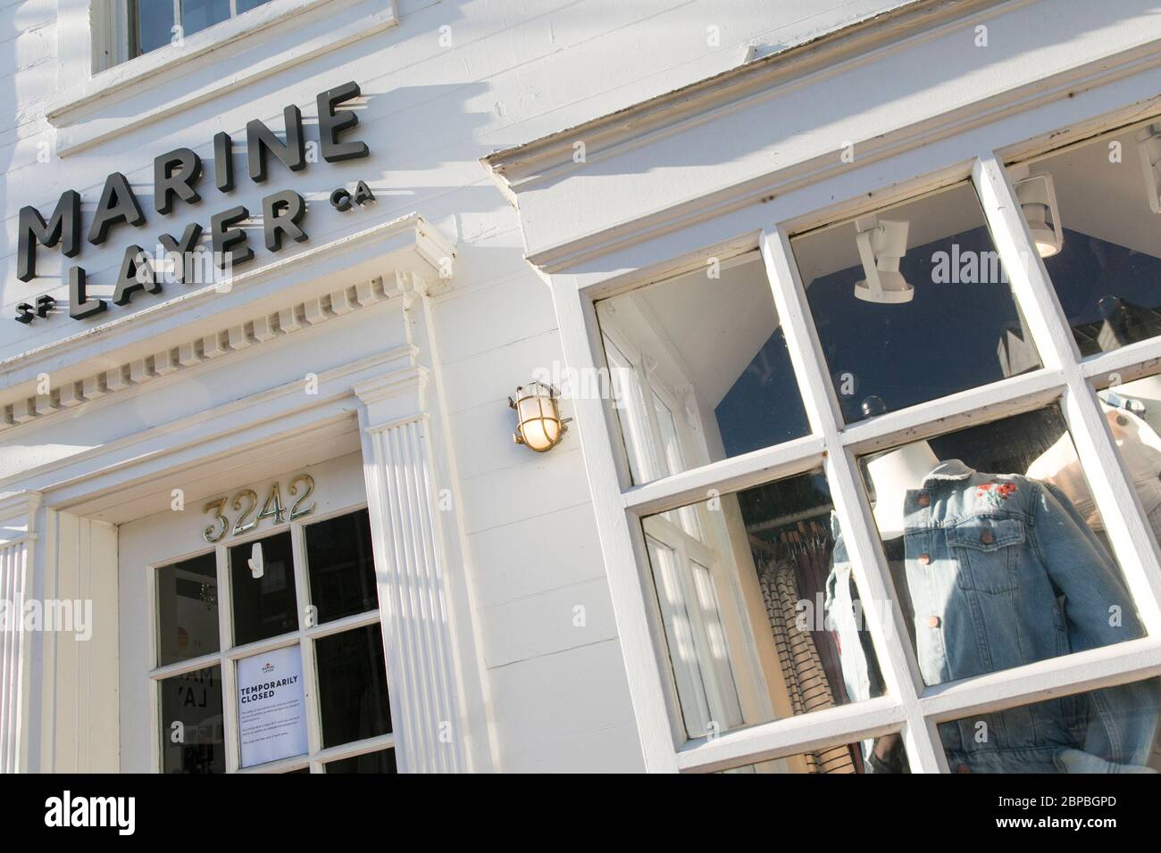 A logo sign outside of a Marine Layer retail store location in ...