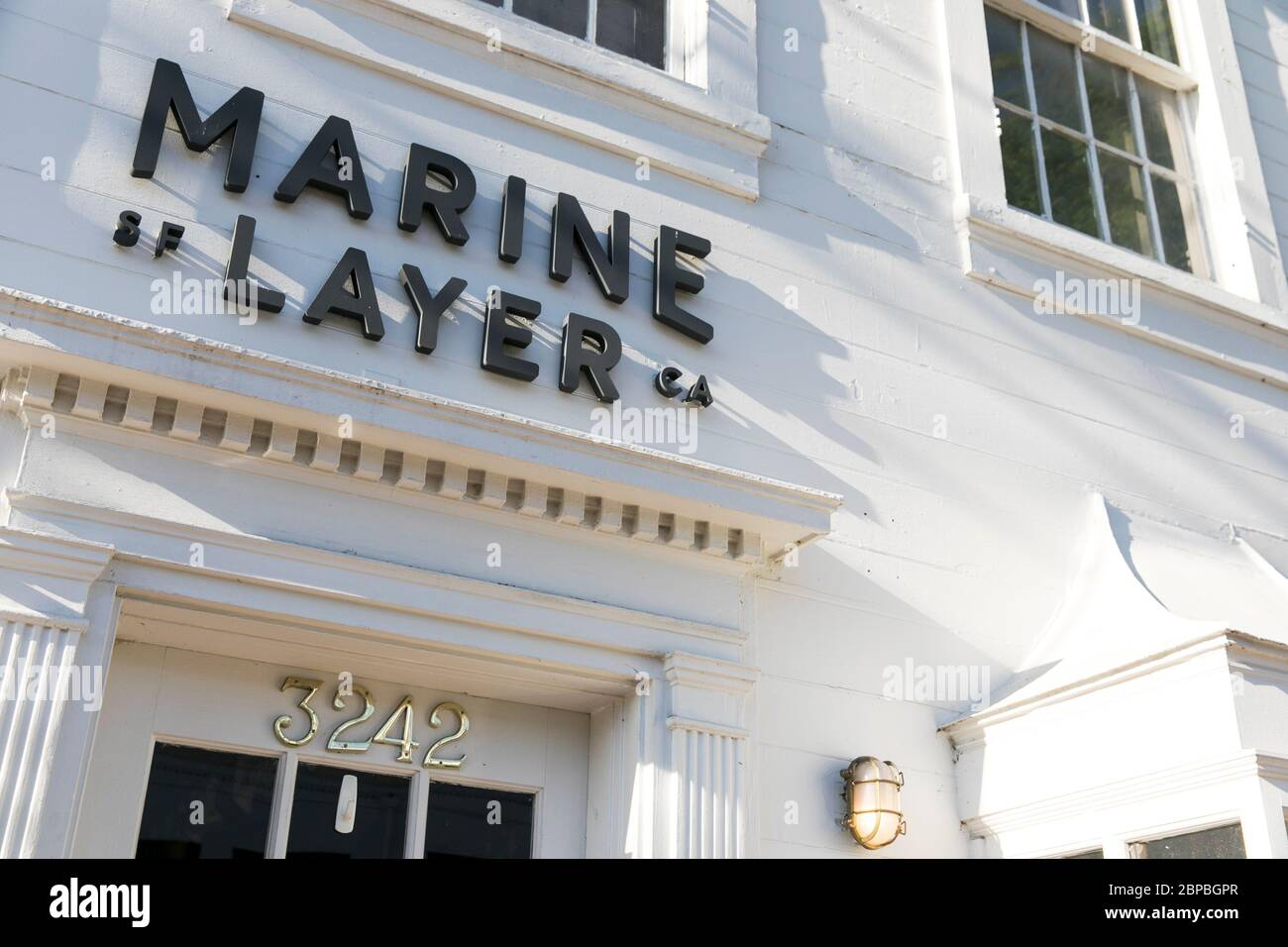 A logo sign outside of a Marine Layer retail store location in ...