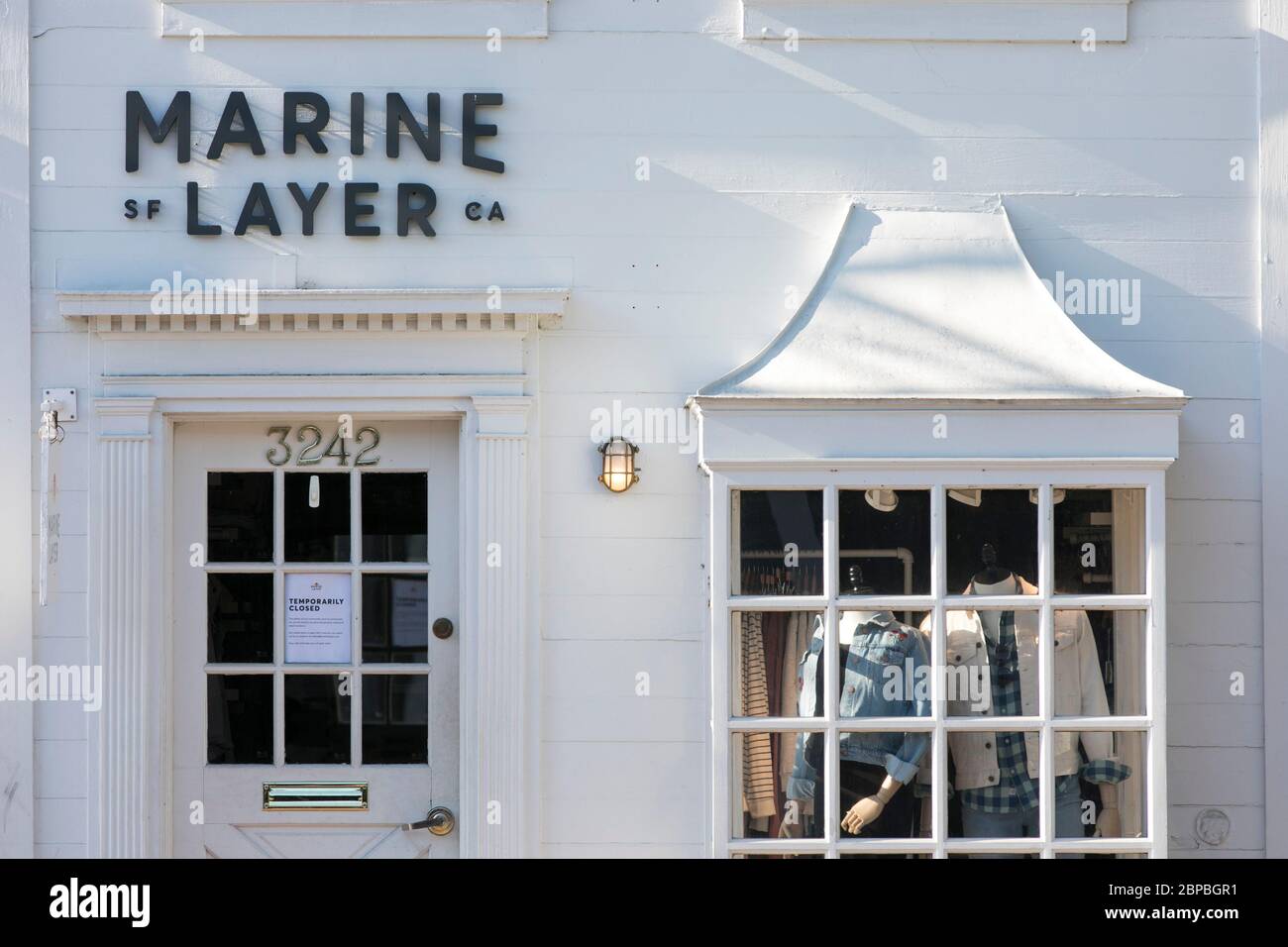 A logo sign outside of a Marine Layer retail store location in ...