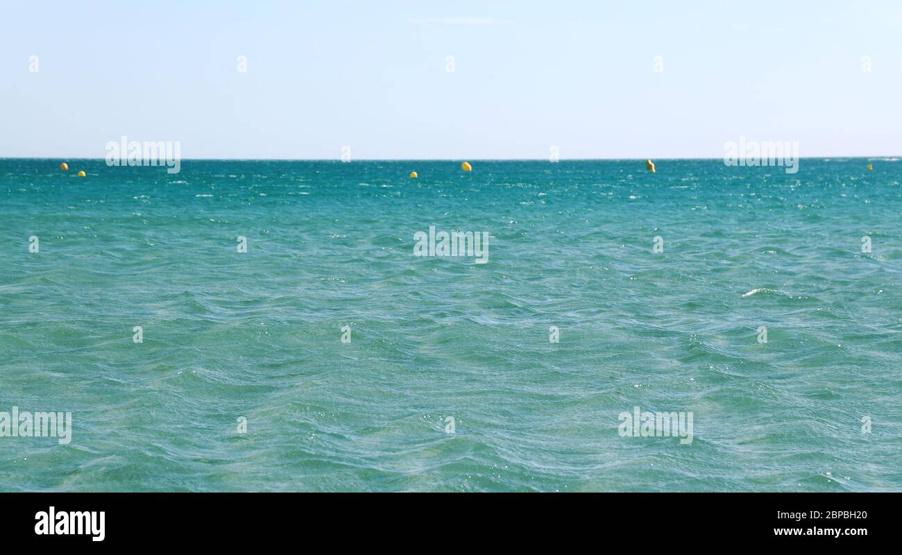 Tranquil seascape with calm turquoise sea water ripples and waves under clear day blue sky, high ...
