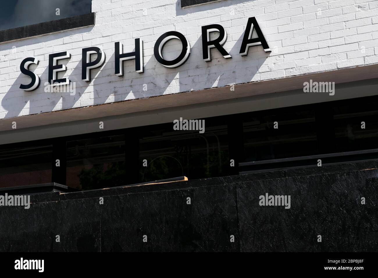 A logo sign outside of a boarded up and closed Sephora retail store ...