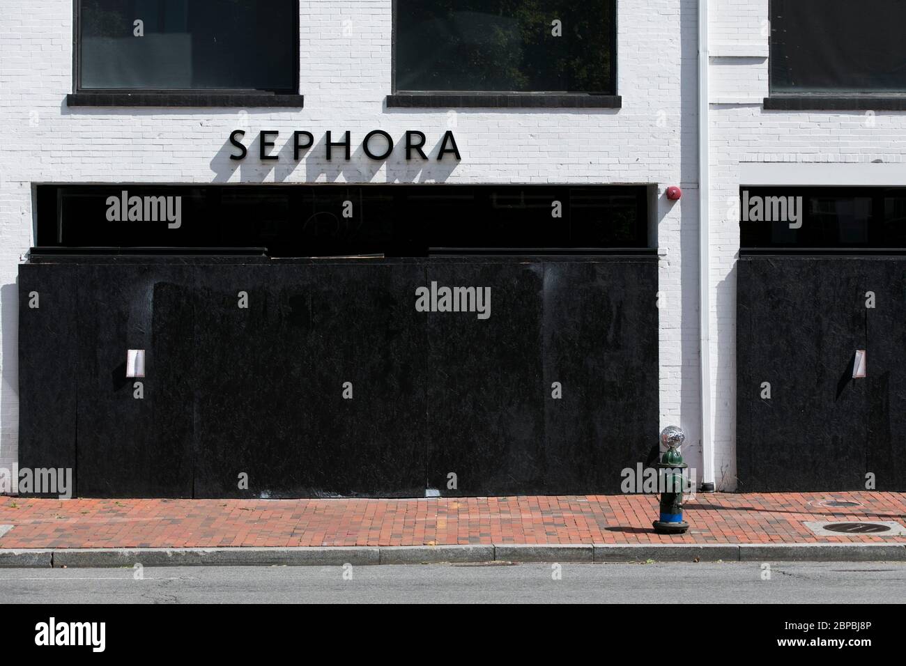 A logo sign outside of a boarded up and closed Sephora retail store ...