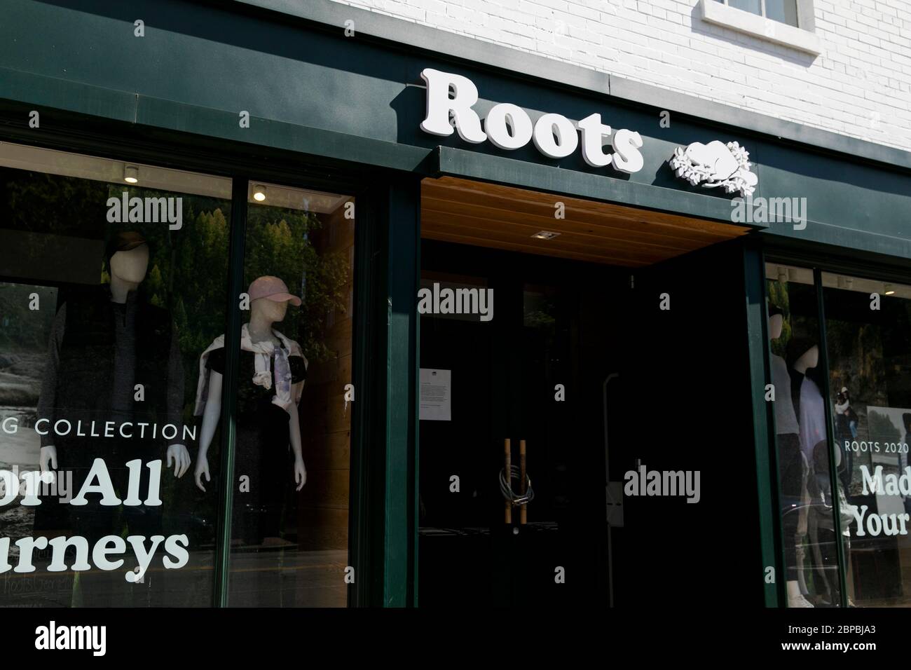A logo sign outside of a Roots retail store location in Washington, D.C ...