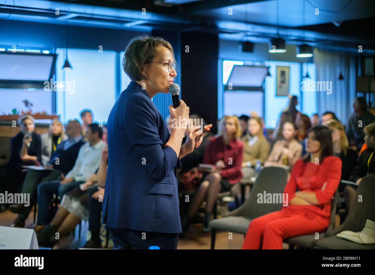 Female presenter speaks to audiences Stock Photo - Alamy