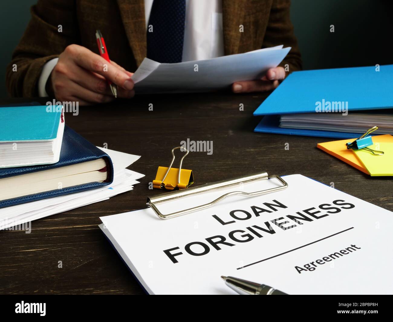 Loan forgiveness form and man checks documents Stock Photo - Alamy