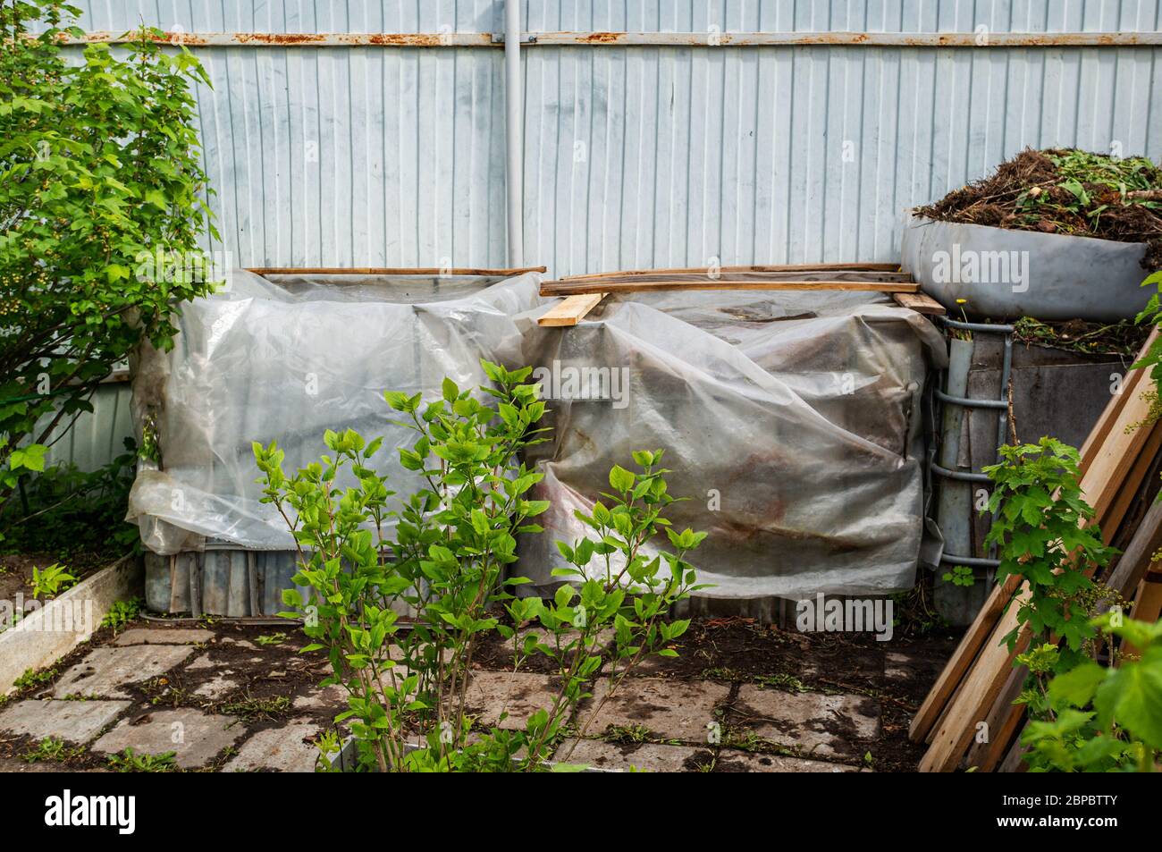 Plastic containers are reused for composting waste in the garden. fresh ...