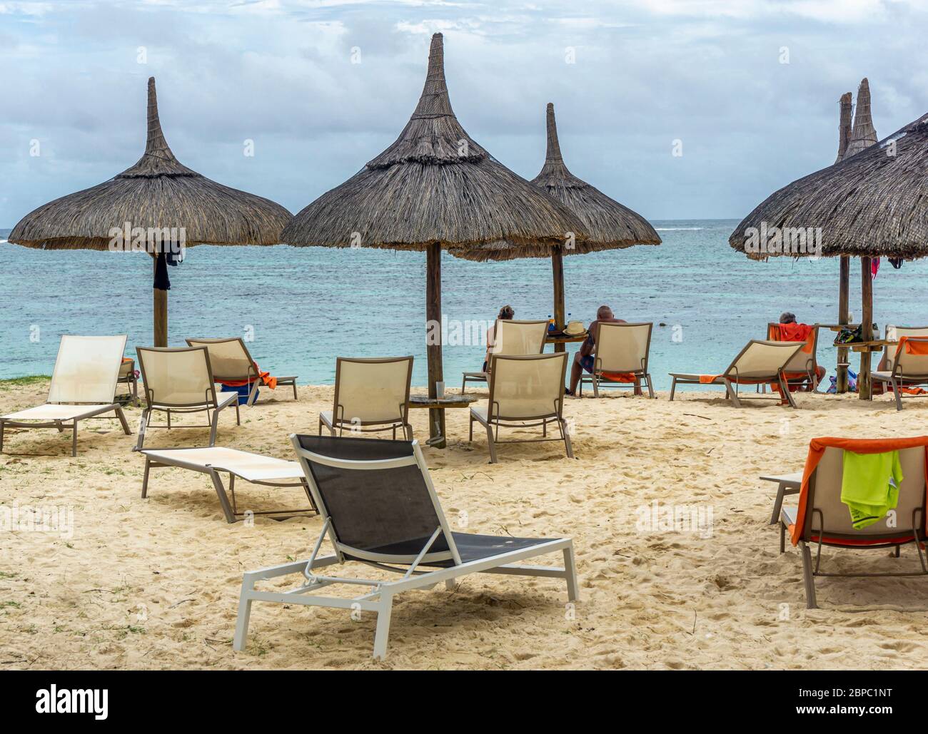 Straw huts and relaxation chairs on the beach of a tropical resort in ...