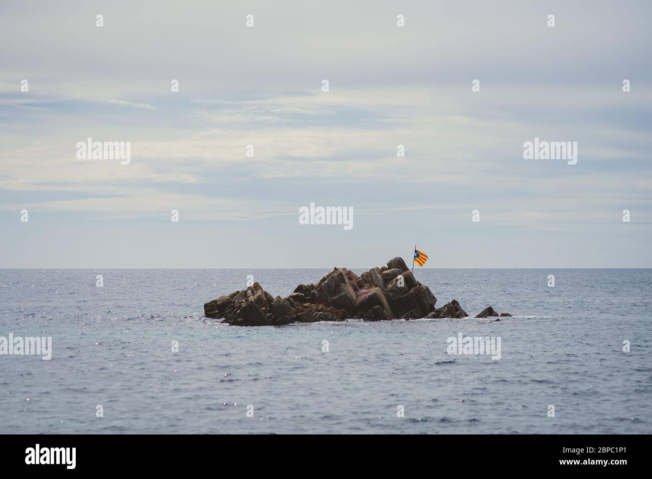 flag flies on a desert islet in the middle of the sea Stock Photo - Alamy