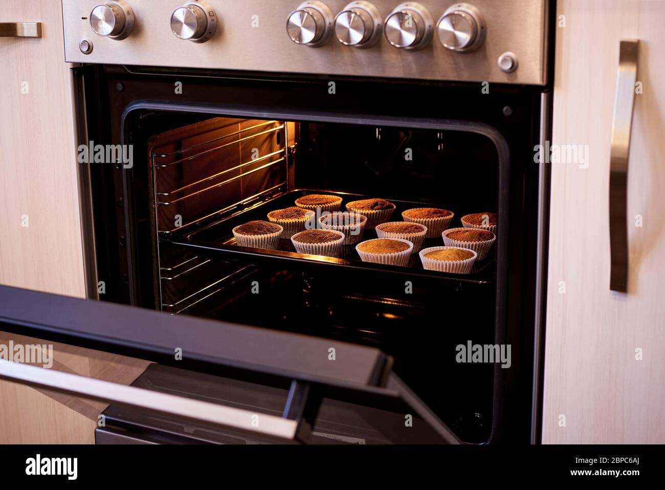 Baked cupcakes in an open oven close-up Stock Photo - Alamy
