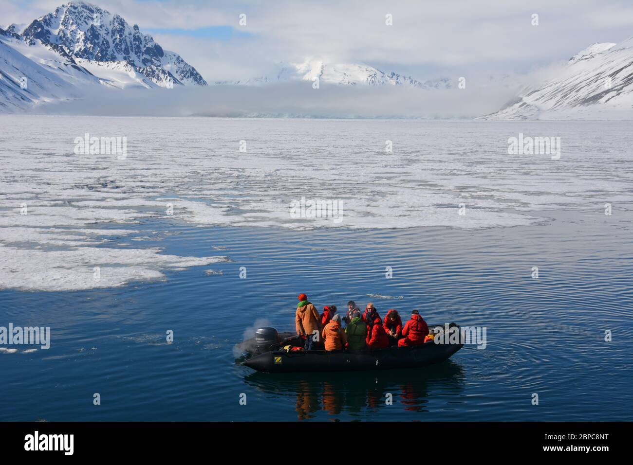 A group of adventure cruise tourists takes in the Svalbard scenery from ...
