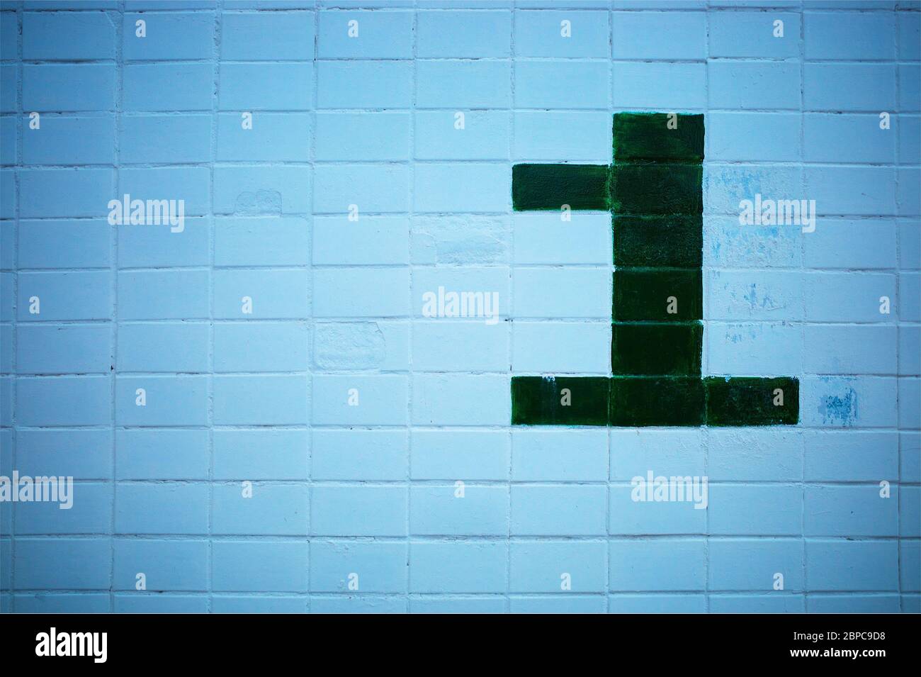 Green "number one" on the wall background Stock Photo - Alamy