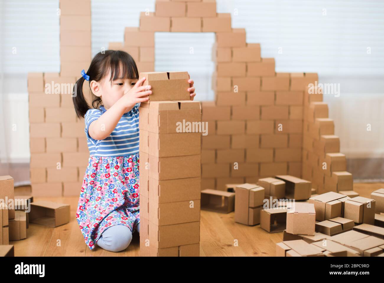 toddler girl use carton blocks to buid house at home Stock Photo - Alamy