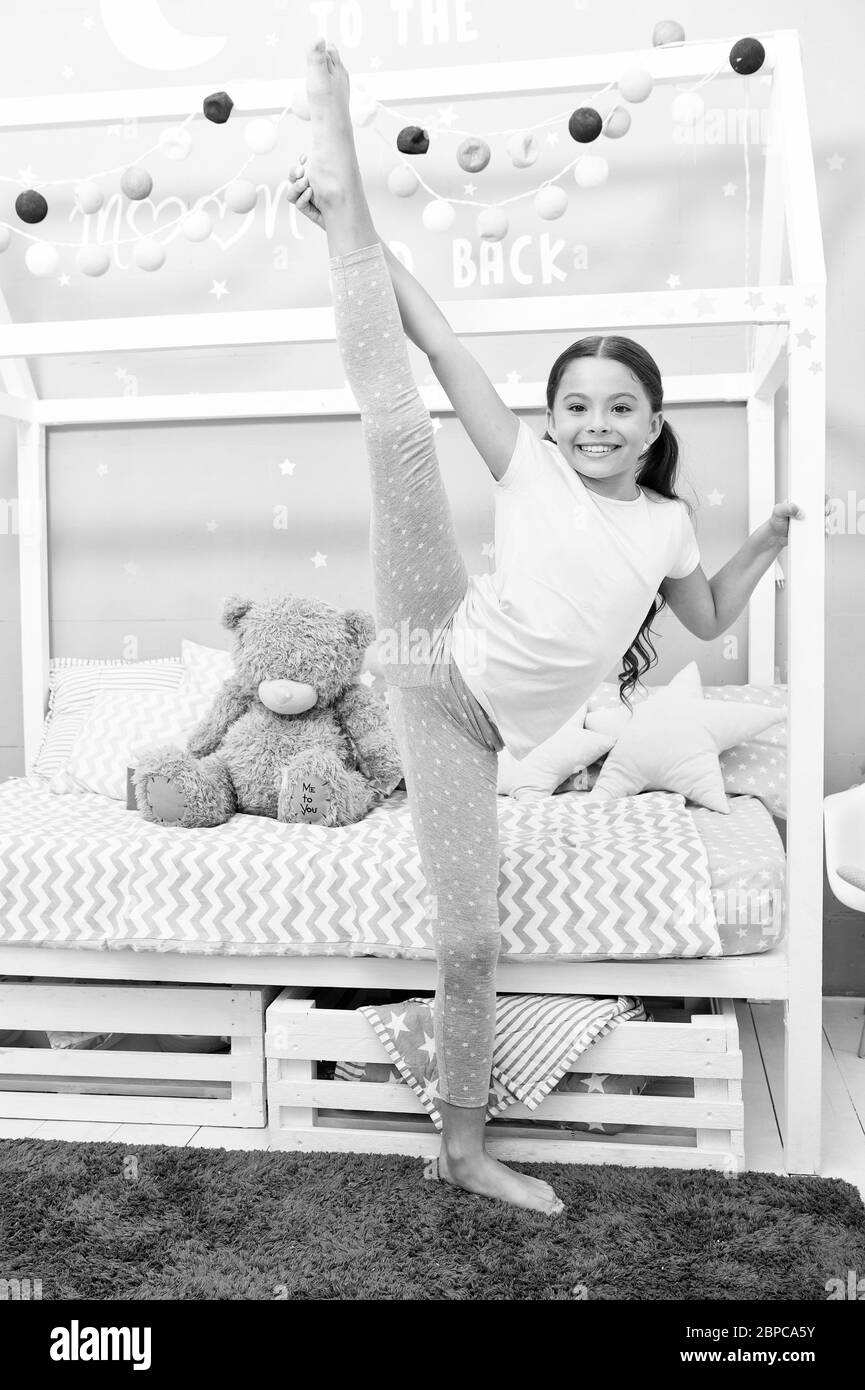Improve flexibility. Girl child split in bedroom. Kid prepare go to bed ...