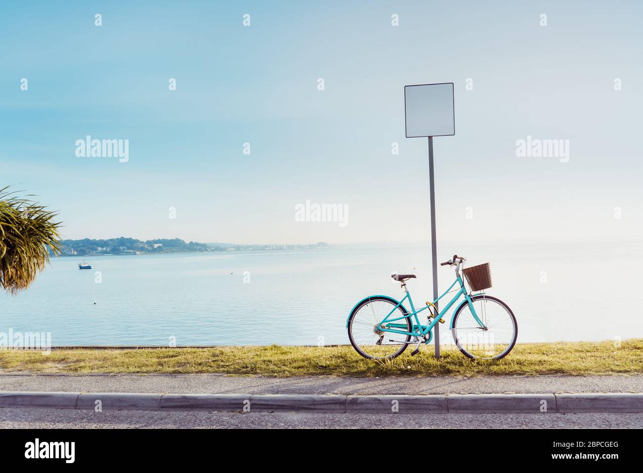 Vintage style bright bicycle parked near a blank road sign in the ...