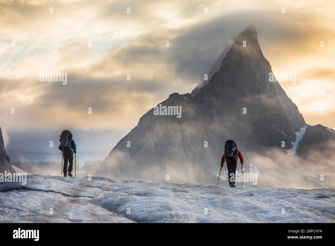 Two backpackers hiking towards Mt. Loki, Baffin Island, Canada Stock ...