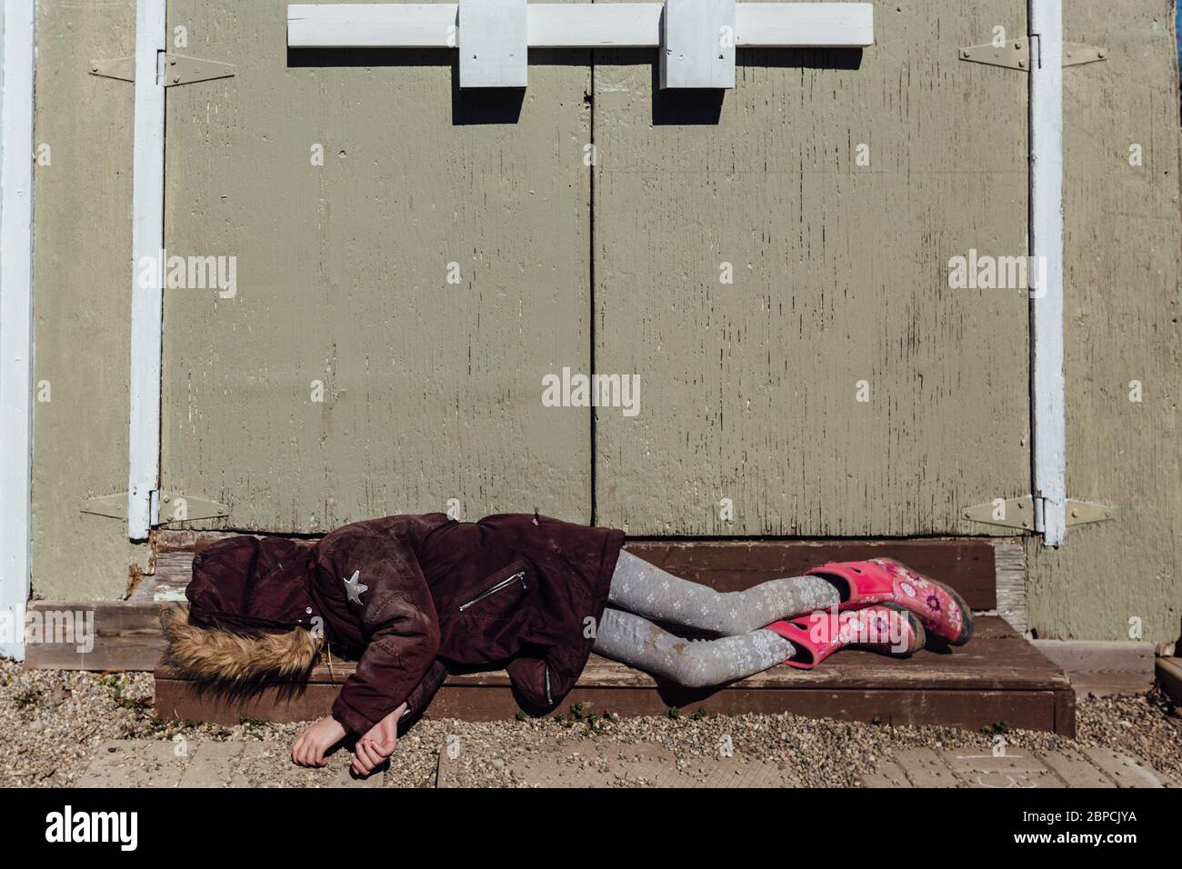 Young gilr lying on steps being bored Stock Photo - Alamy