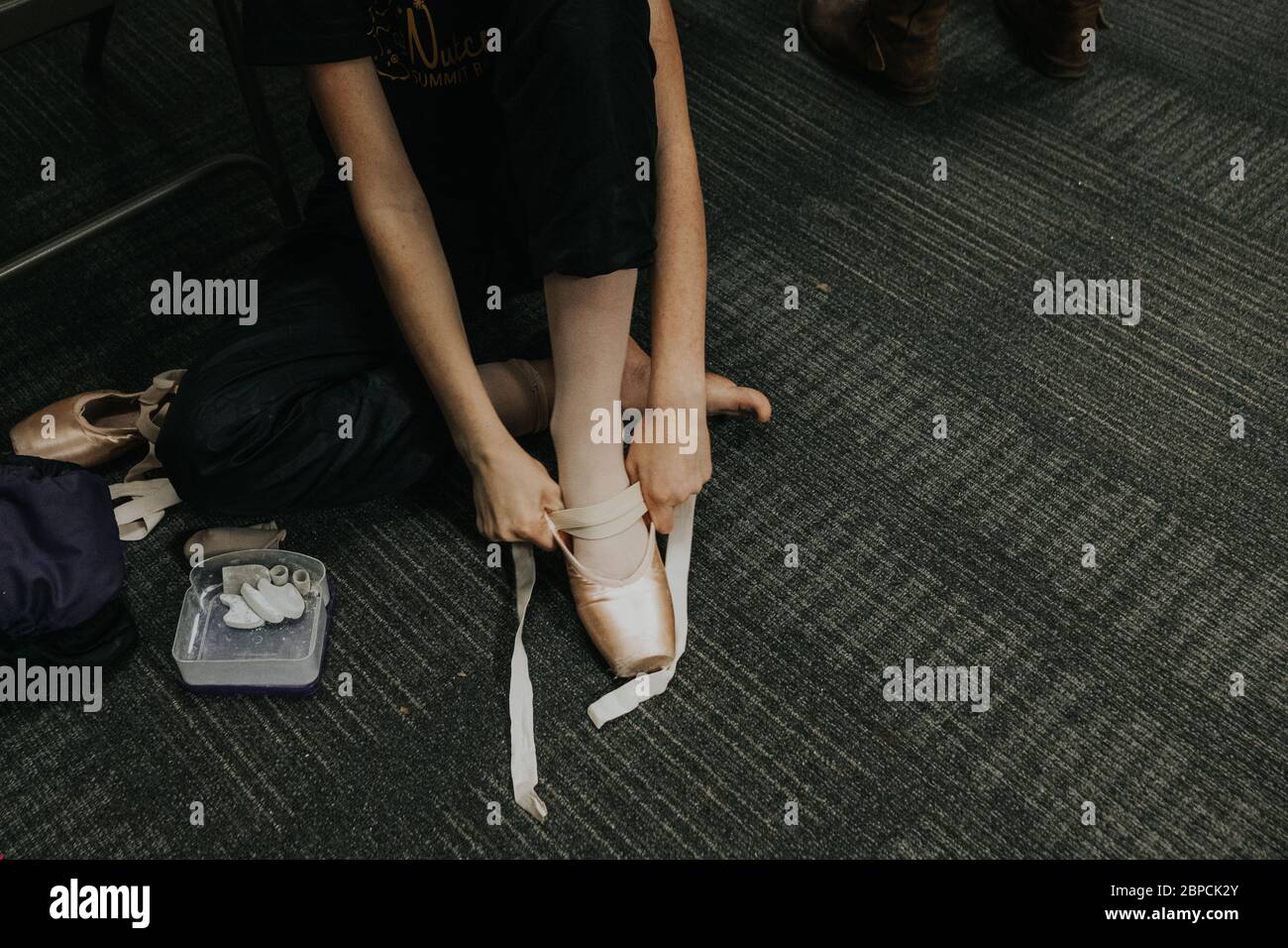 overhead shot of girl putting on ballet point shoe Stock Photo - Alamy