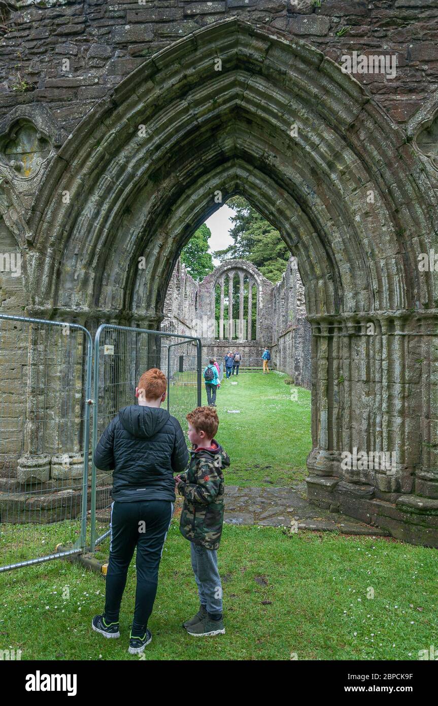 Two boys in front of the Gothic arch of the Inchmahome Priory Stock ...