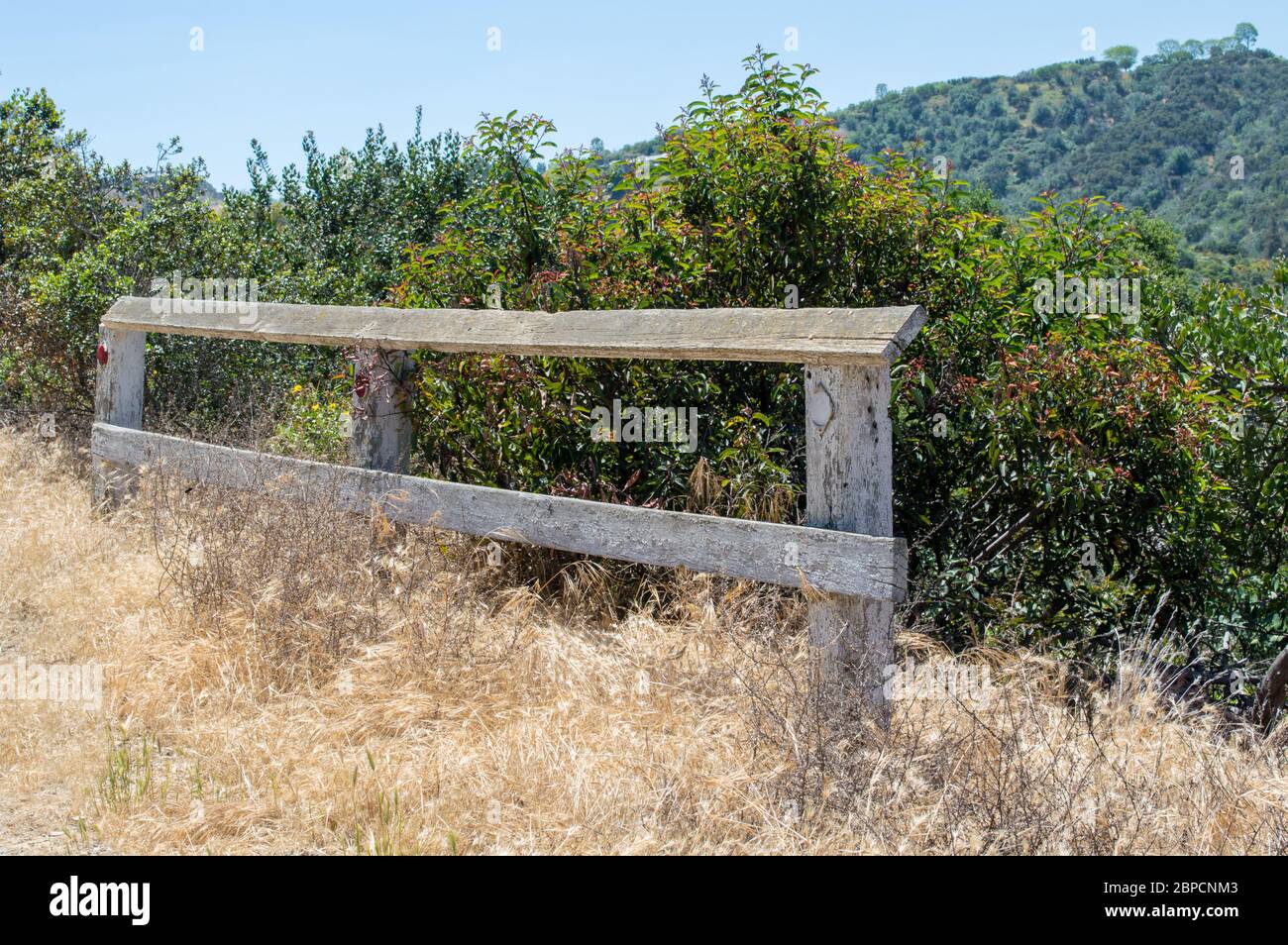 an abandoned wooden fence section used as a dead end road barrier on a ...