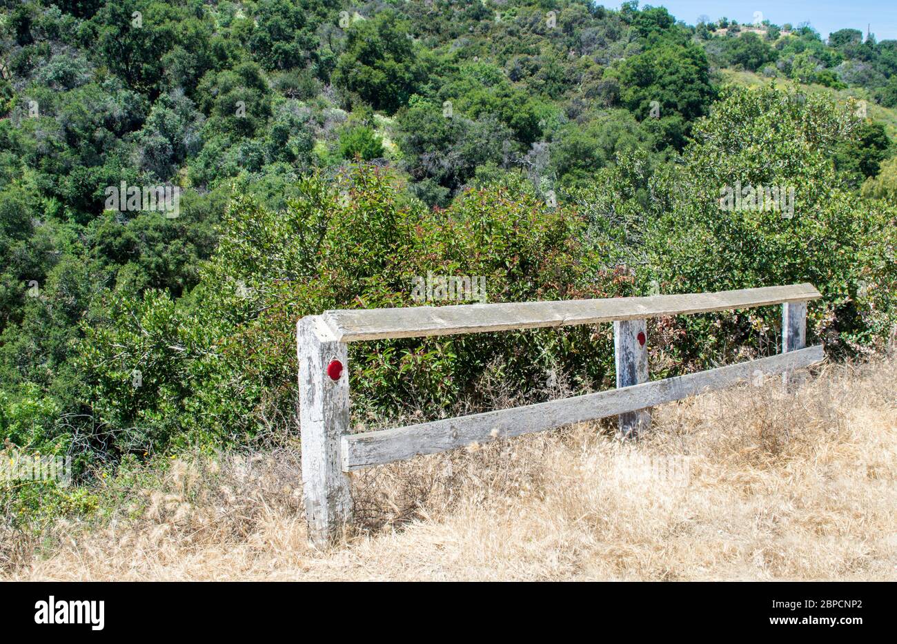 an abandoned wooden fence section used as a dead end road barrier on a ...