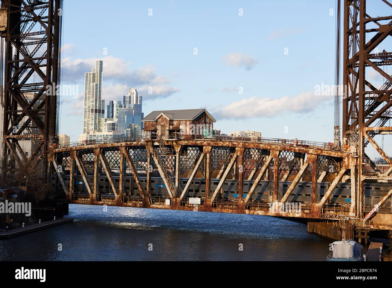 A rusted tender house sits atop a railroad bridge for passing trains ...